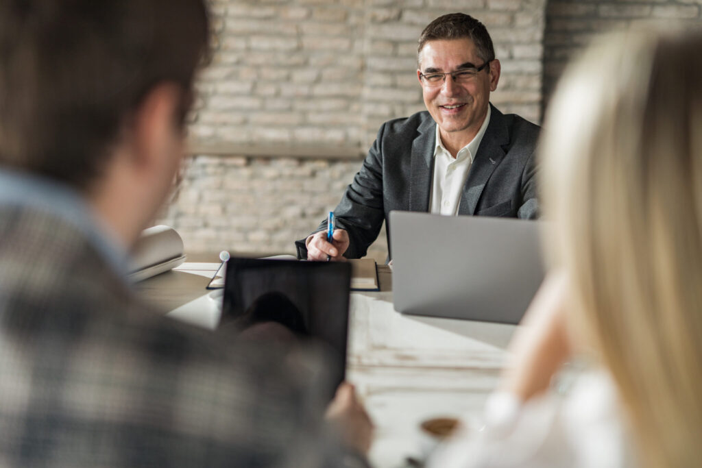 Happy insurance agent having a meeting with his customers in the office ...